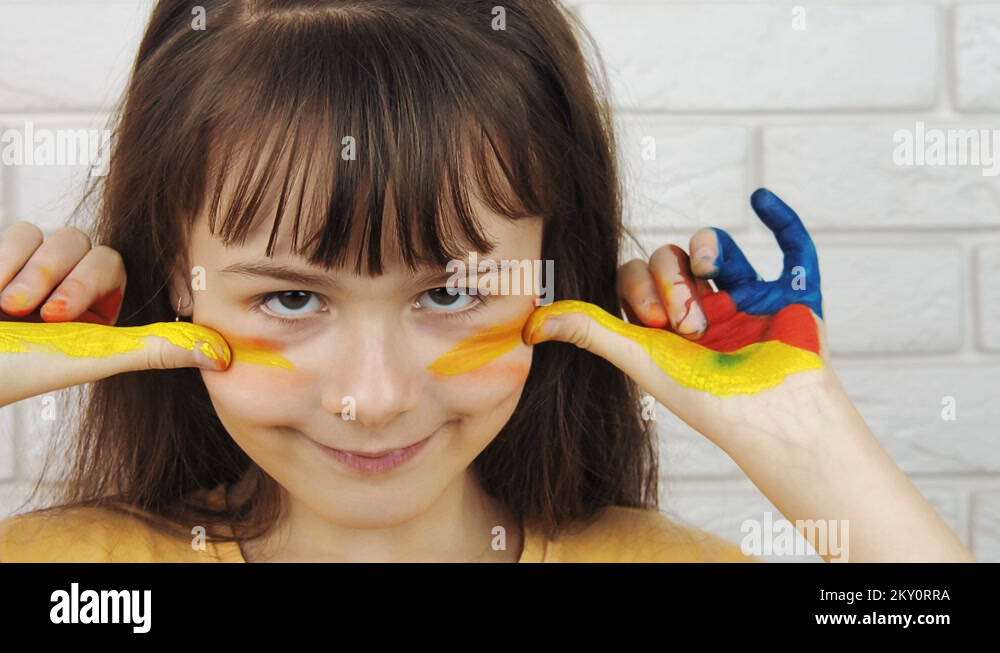 Child in paint. The little girl smears her face with paint Stock Video ...