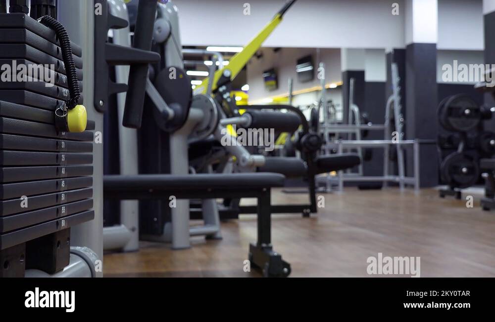 The interior of an empty gym - blurred - weights on a machine in the ...