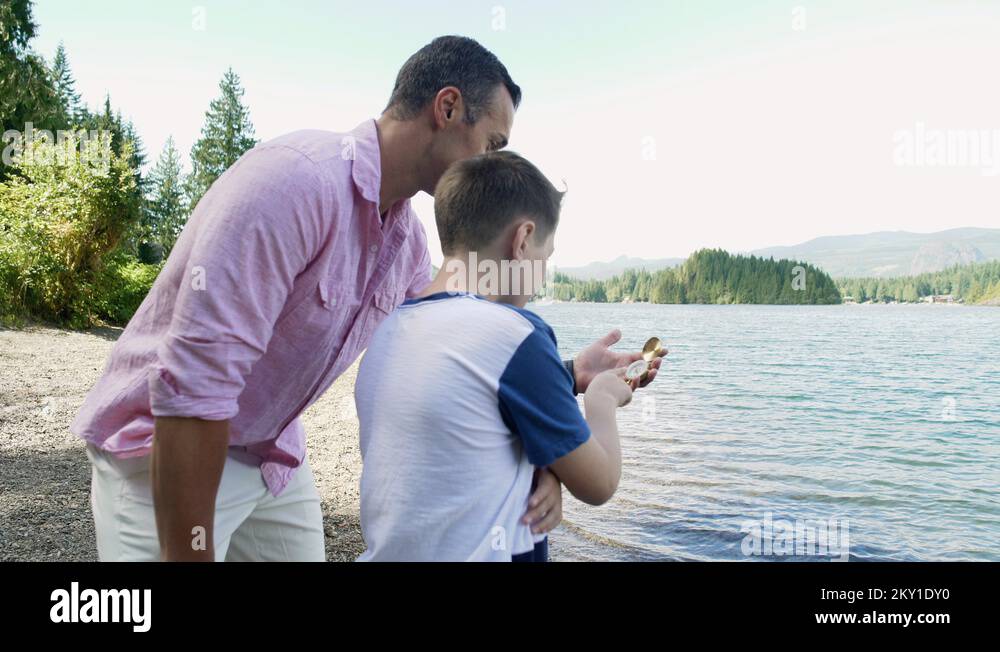 Father teaching son how to use compass by lakeside, Lake Connaught ...
