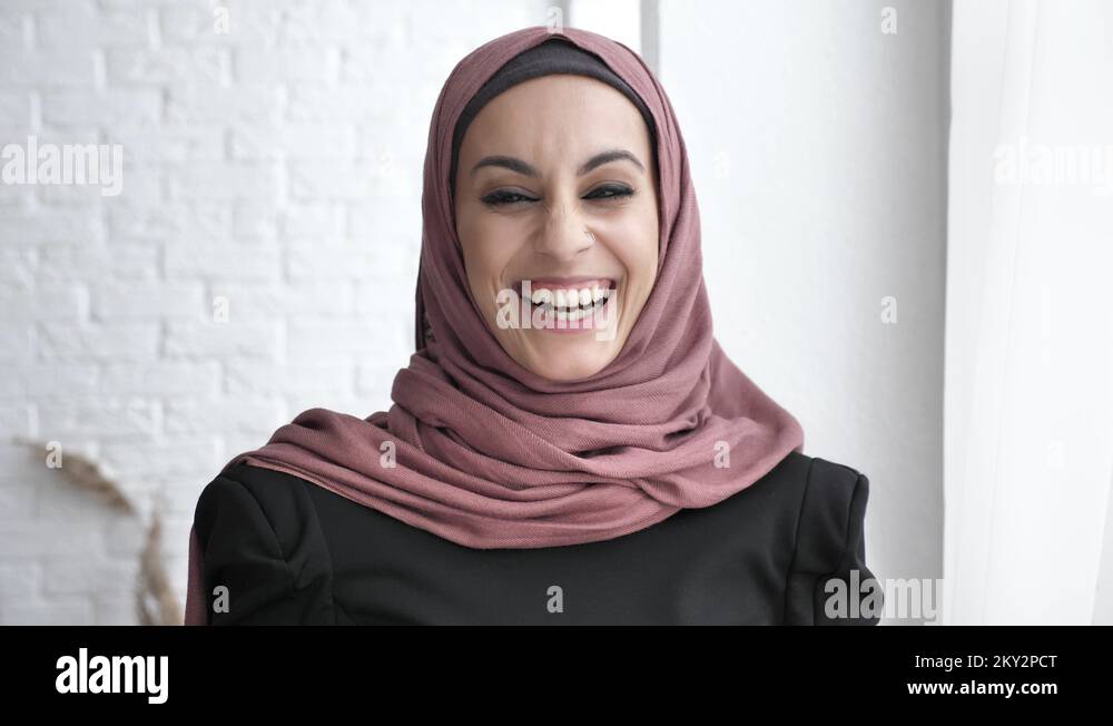 Young Indian girl in hijab smiling, laughing, shaking her head, yes ...