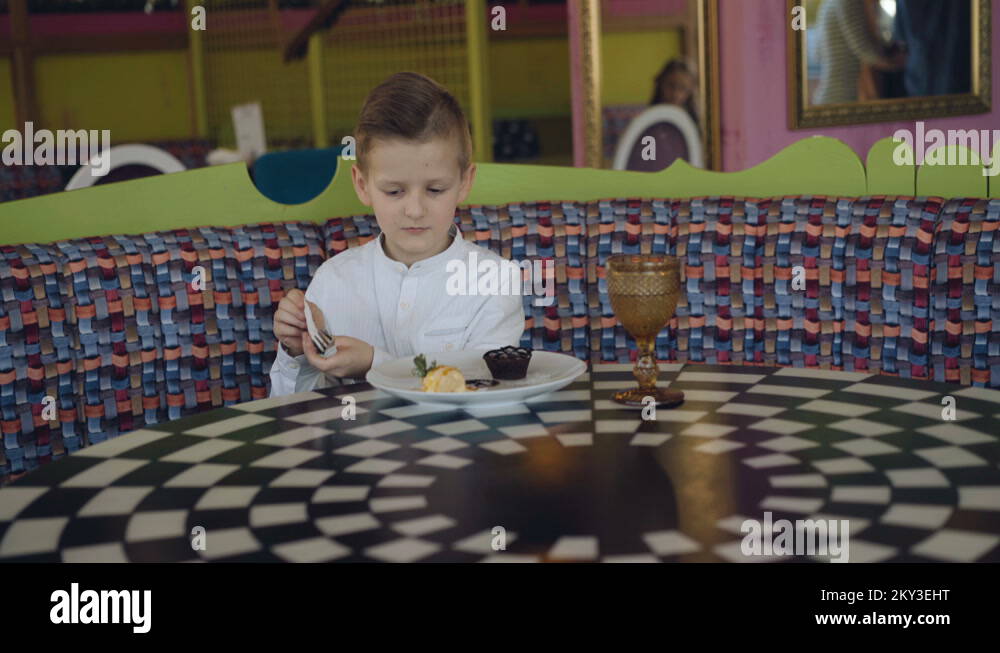 Handsome smiling boy starts to eat a tasty dessert in cafe. 4K Stock ...
