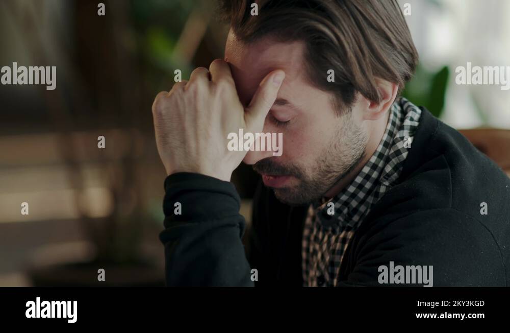 Emotional bearded young man rocking to and fro before swinging round ...