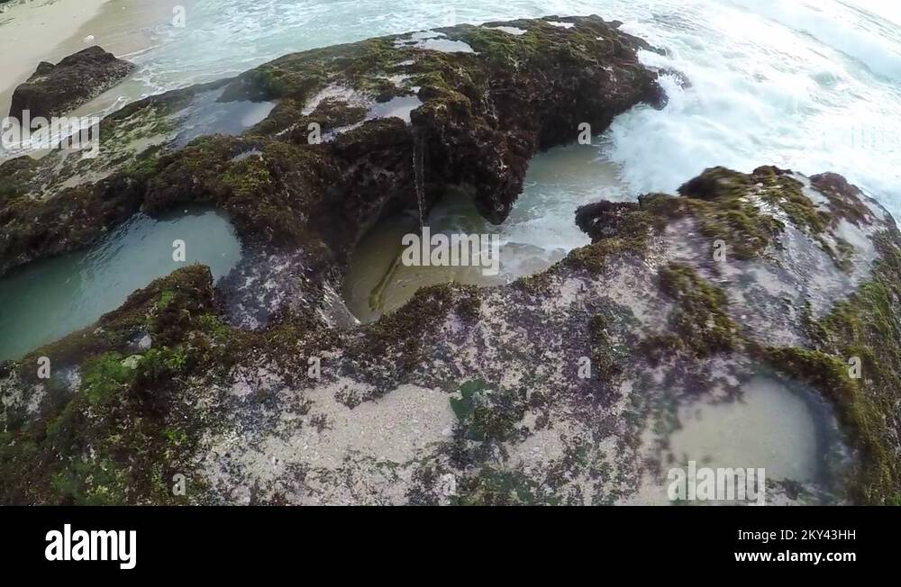 Water is being recruited into a slit on the beach and sprinkled with ...