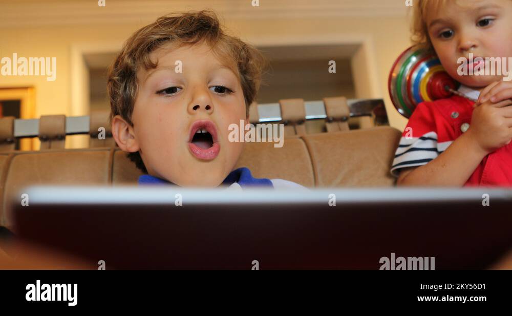 Children starring at tablet device. Candid authentic 4K clip of kids ...