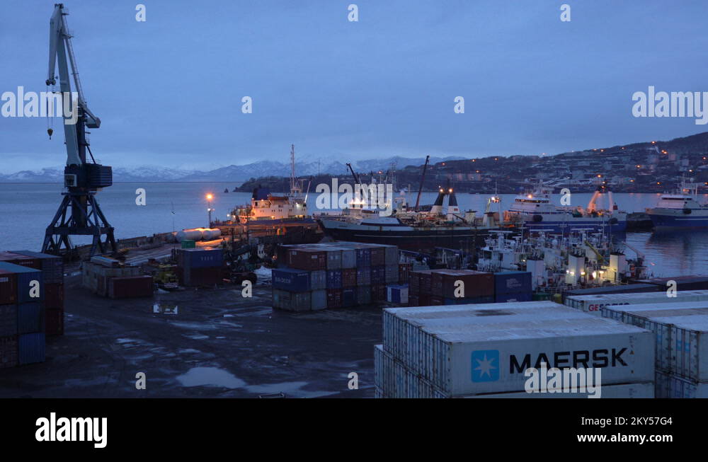 Night view of containers with cargo and fishing ships trawlers at pier ...