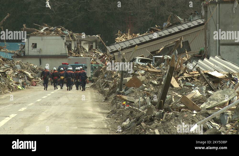 Japan Tsunami Aftermath - Rescuers Walk Through Destroyed Streets Stock ...