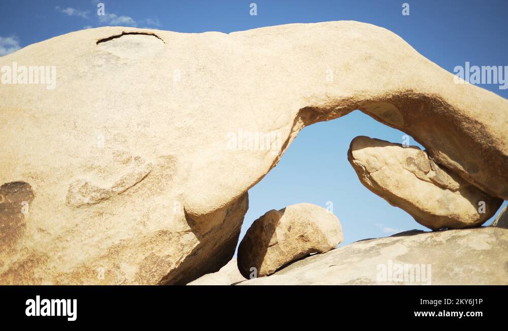 A small rock arch with a saturated sky and clouds for green screen ...