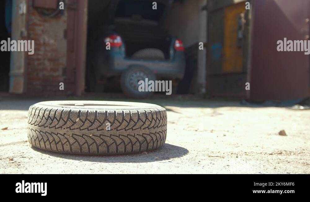 Rolling tire on the ground in front of car garage Stock Video Footage ...