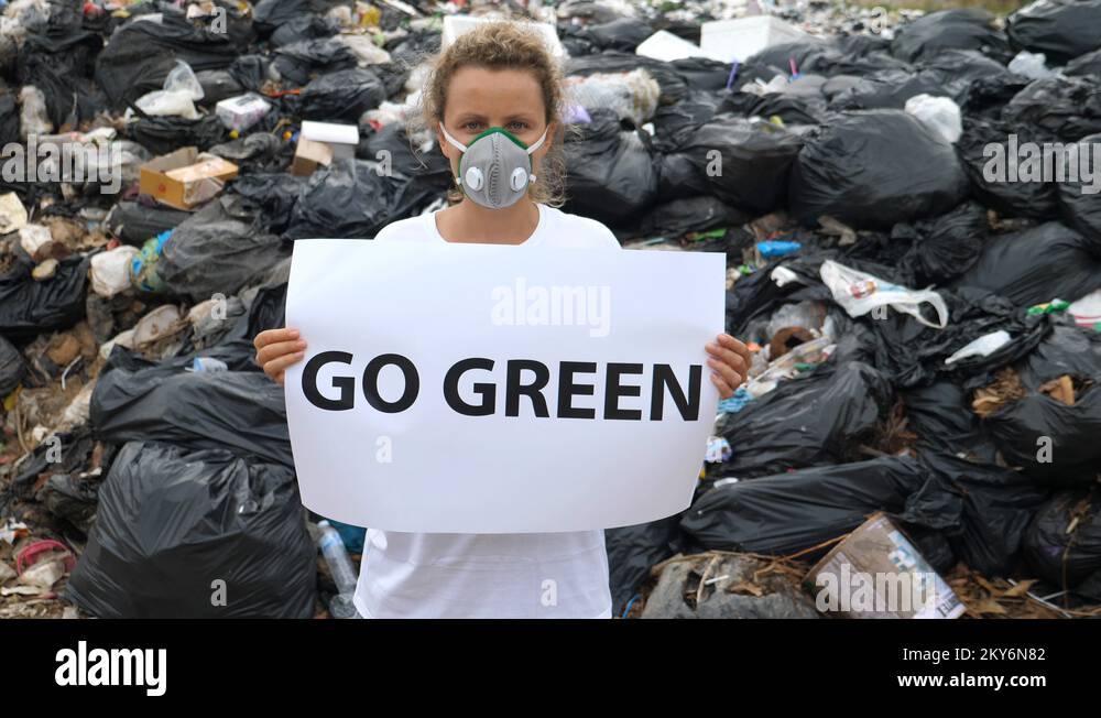 Woman Holding" Go Green" Poster On Waste Dump. Recycle, Eco, Reuse ...
