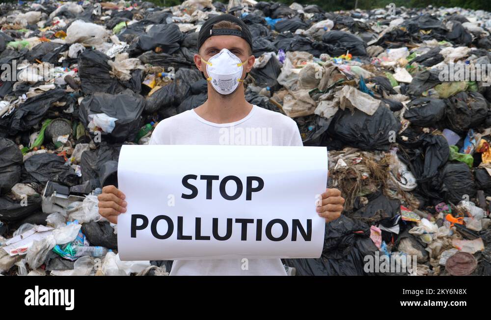 Man Activist In Mask Holding Stop Pollution Poster Standing At Garbage ...