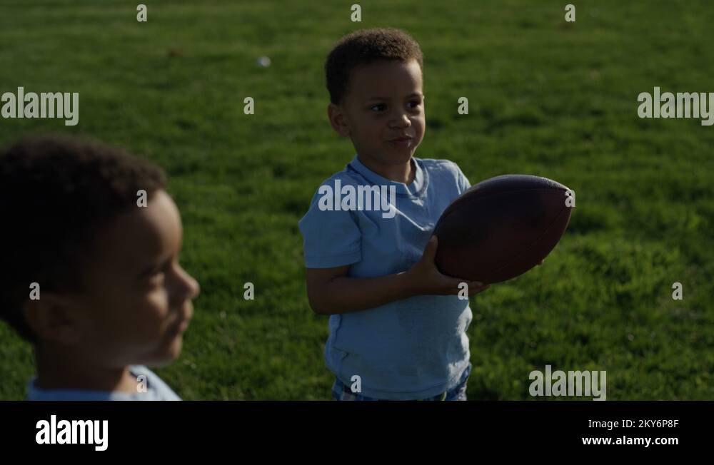 Two kids playing football in grass Stock Video Footage - Alamy