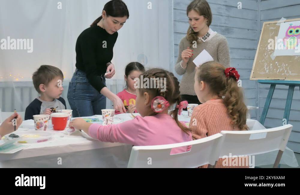 Children boys and girls sitting together around the table in classroom ...