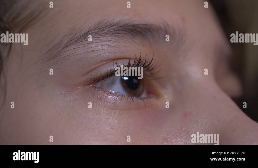 Close-up of a child's human eye. the girl looks closely at the TV ...