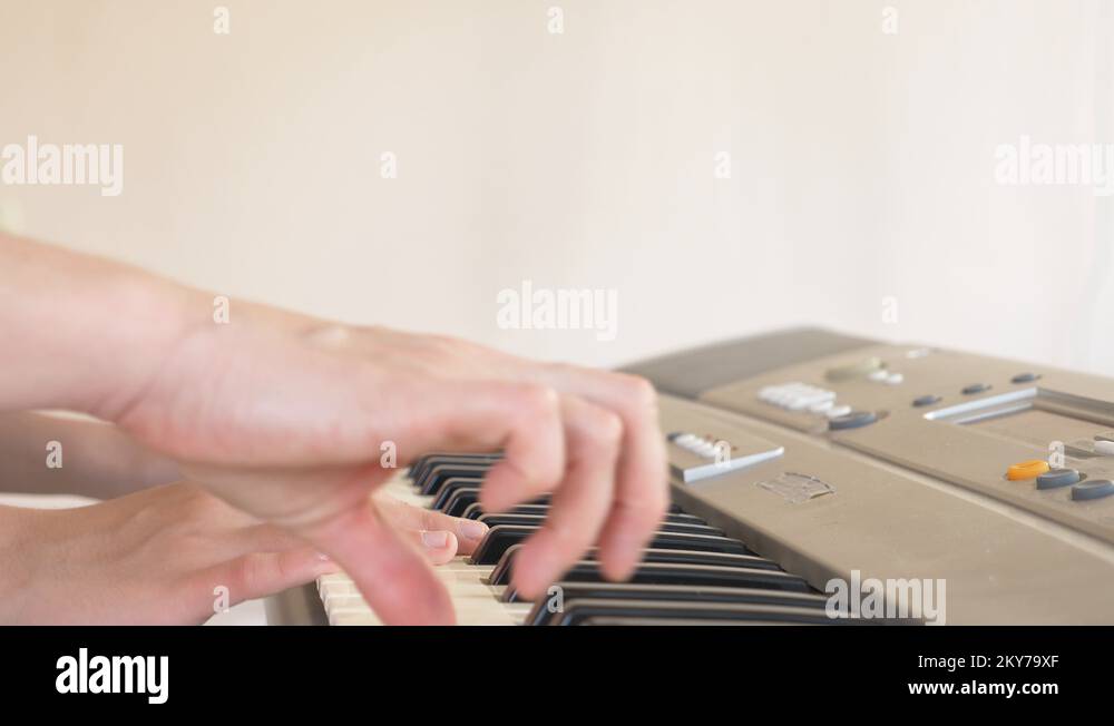 close-up. a piano teacher teaches a child to play the piano, setting ...