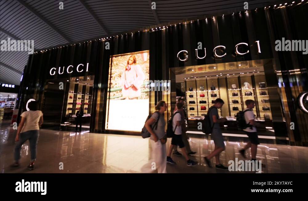 GUCCI shop in Duty Free. Front view and inside view. Tourists walking ...