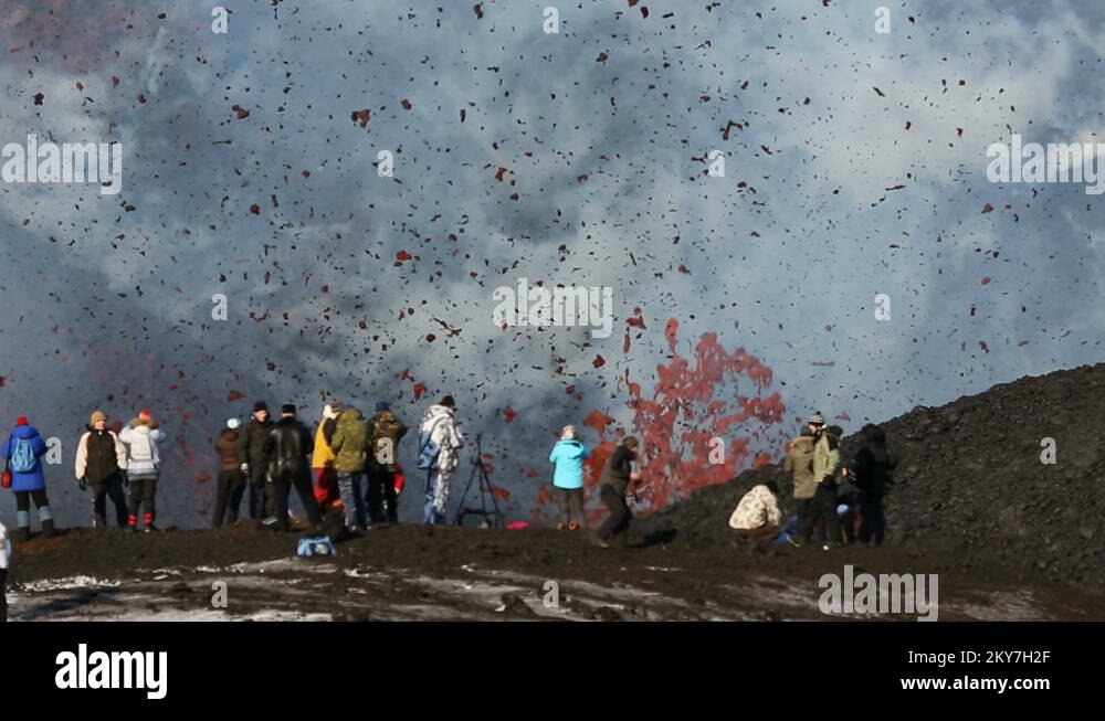 Group of tourists take pictures of flying red hot lava, eruption from ...