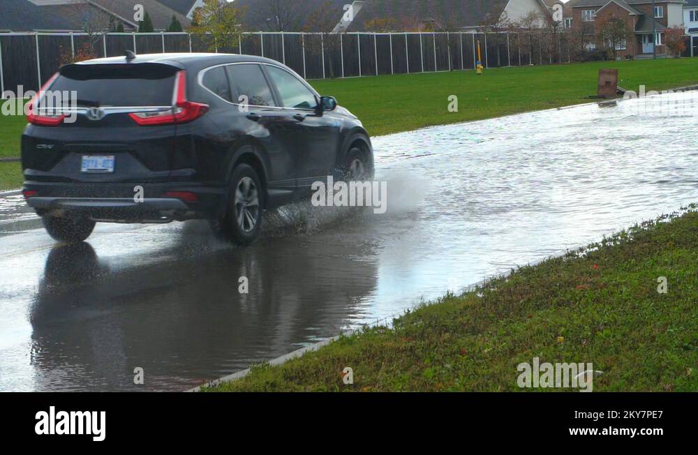 Cars splash water in slow motion on a flooded road Nov 12 2016 Ottawa ...