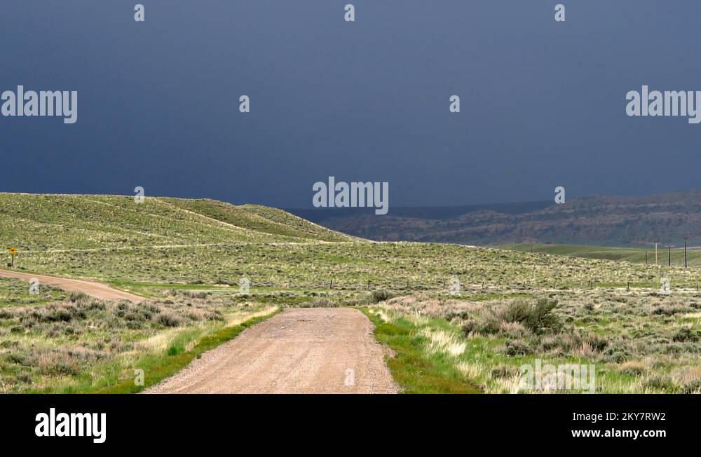 Lightning strikes in dark stormy clouds at the end of a dirt road Stock ...