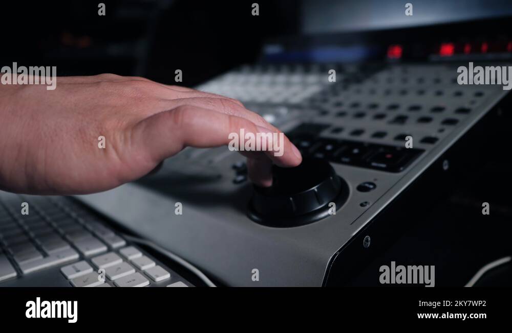 Sound engineer rotates the scroll wheel on mixing console in a ...