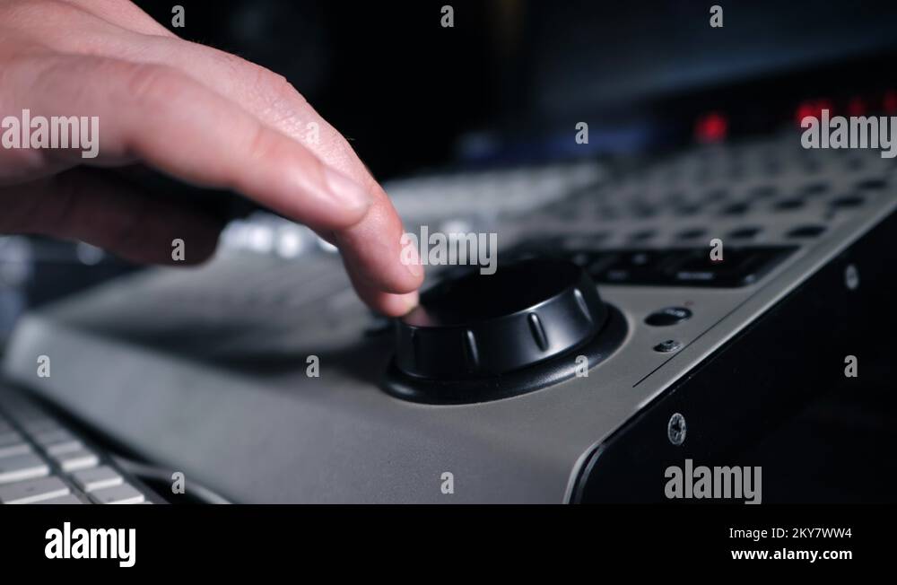 Sound designer rotates the scroll wheel on mixing console in a ...