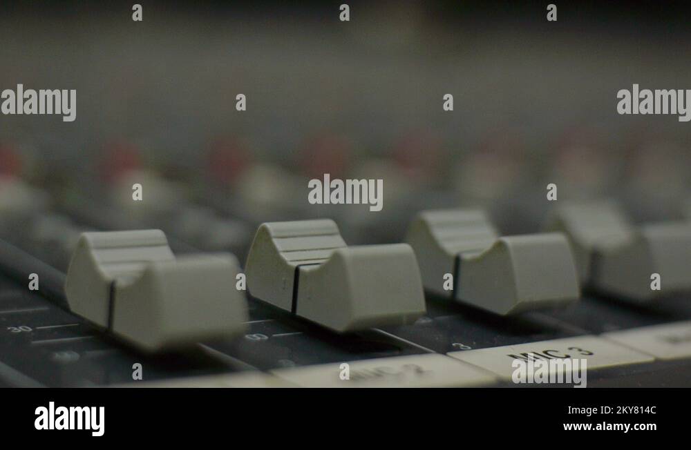 Sound engineer sliding and adjusting the sound levels using a mixing ...