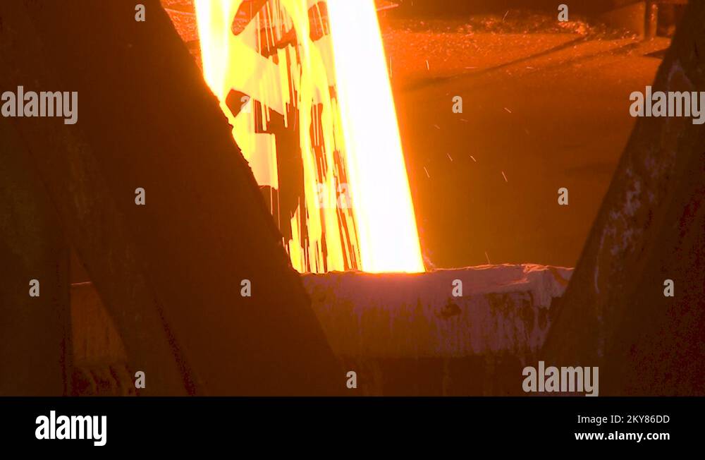 Molten metal pouring out of furnace. Liquid metal from blast furnace ...