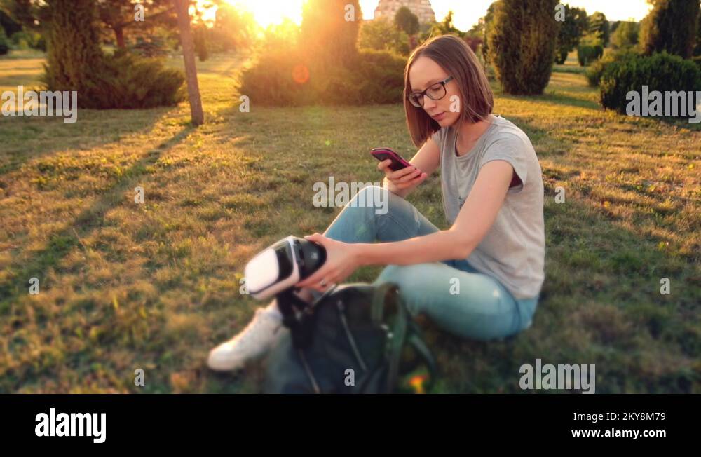 Girl scanning qr code on her virtual reality glasses with smartphone ...
