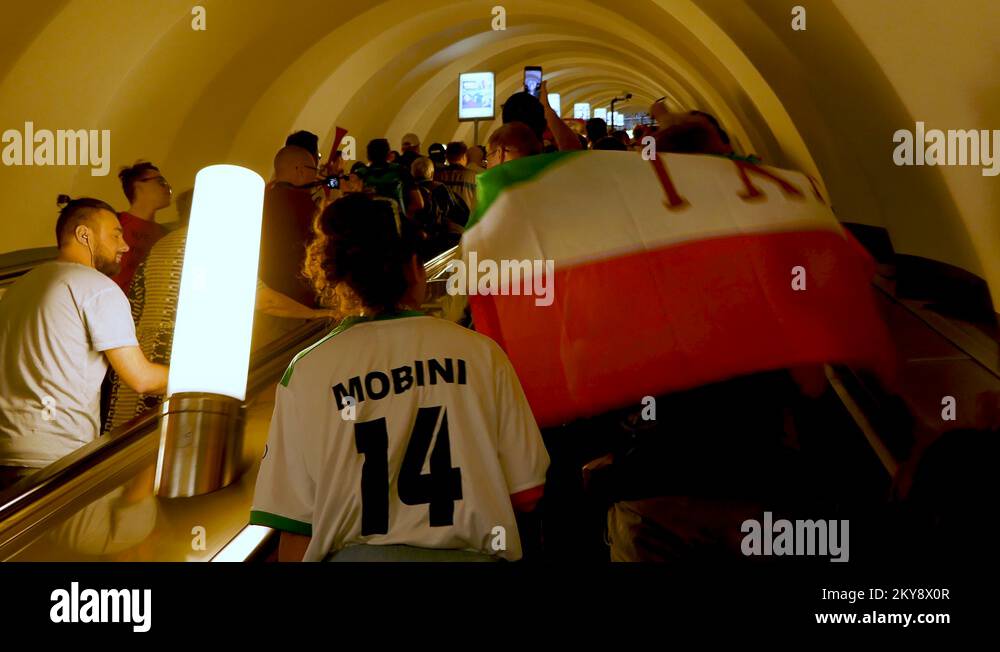 Iran fans moving toward stadium in metro with Iranian flag waving and ...