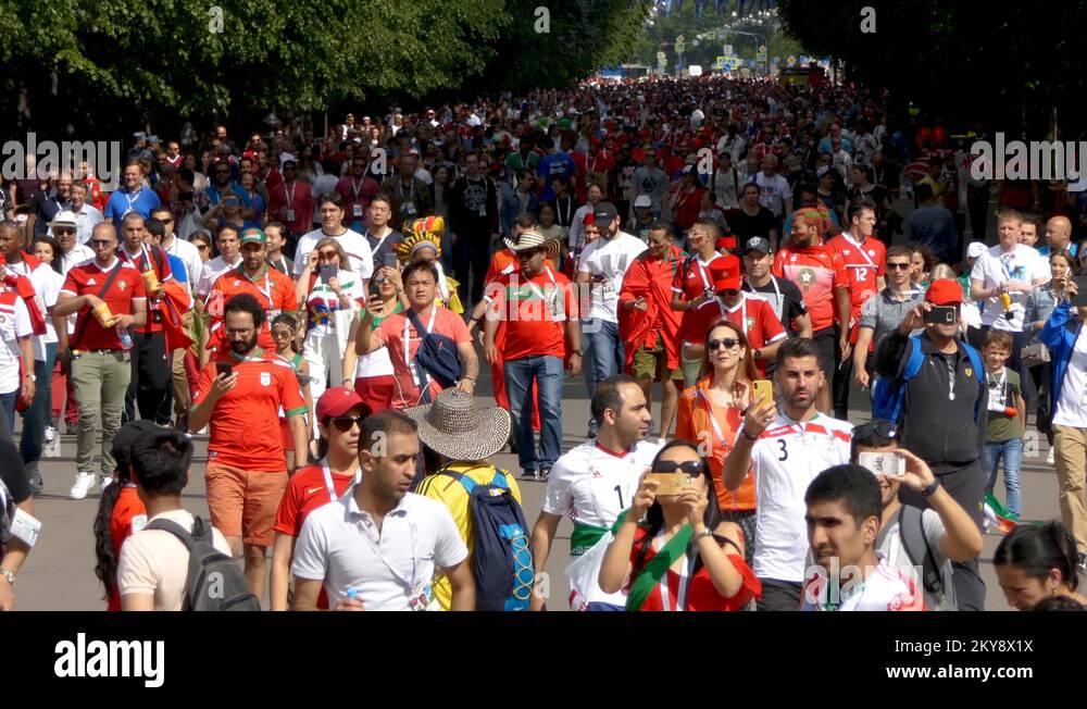 Huge crowd of football fans moving in street flag waving chanting ...