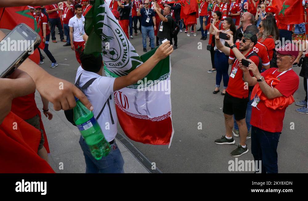 Iranian goes in between Moroccans football fans with flags waving ...