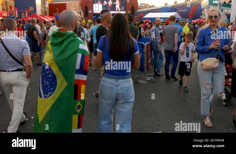 Man wearing a flag of all countries flags standing in street among ...
