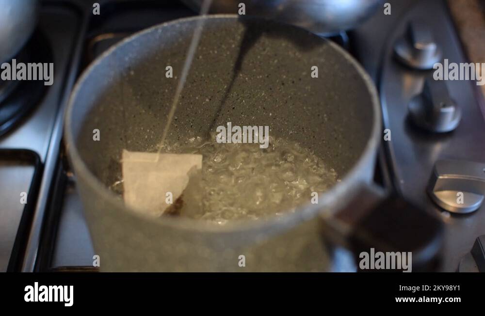 Placing tea bag in boiling water and changes the color of the water ...