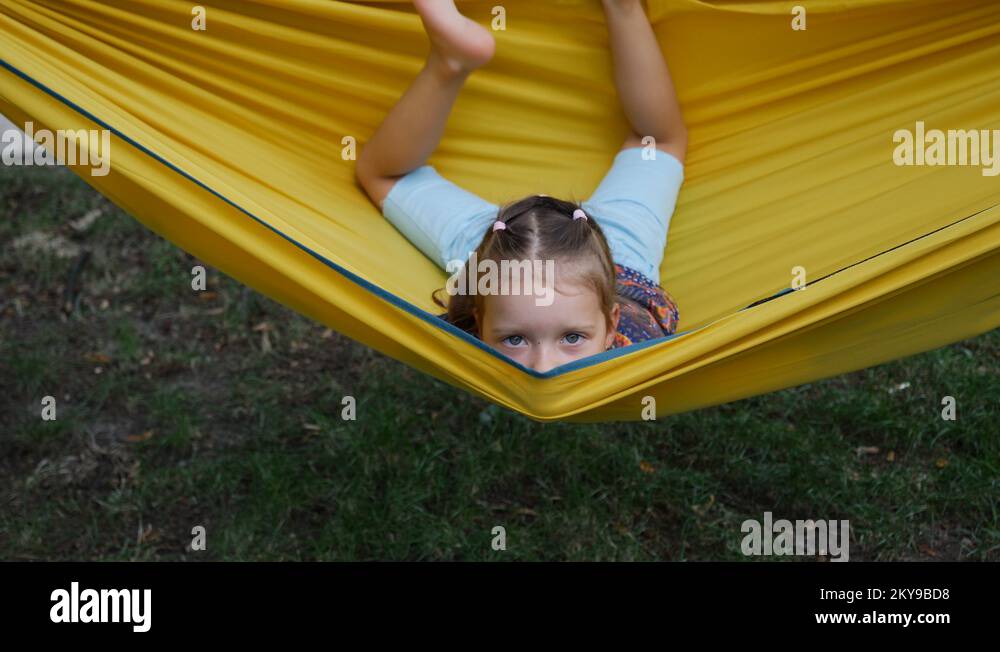 6 Girl child funny amuse enjoy lying in yellow hammock wagging ...