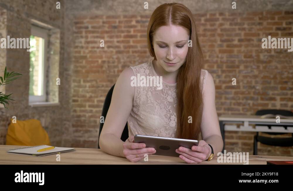 Young cute ginger girl is showing green screen on her tablet, watching ...