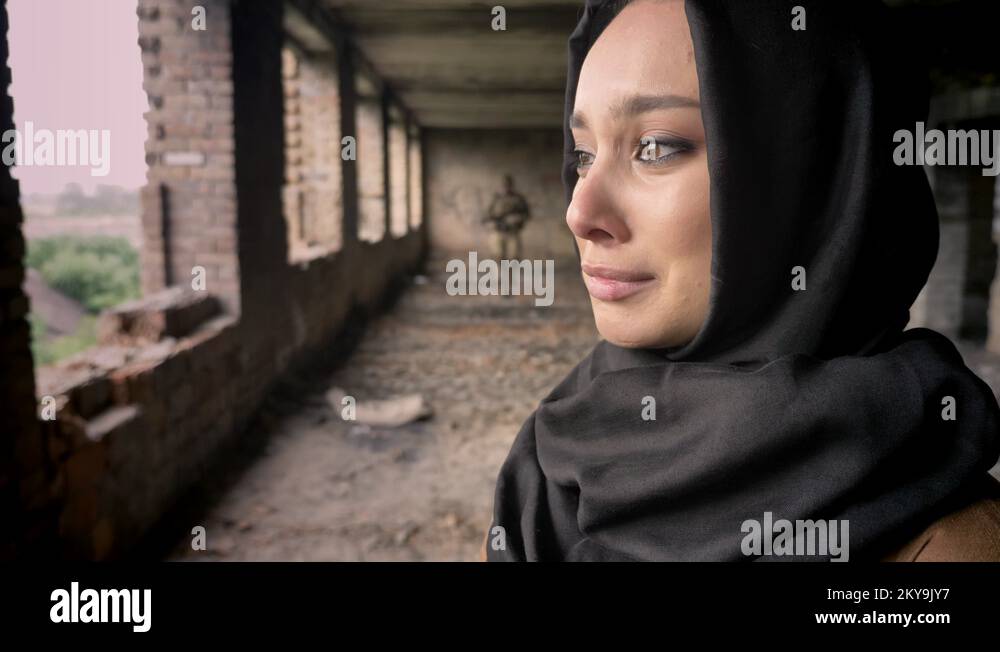 Young Sad Muslim Woman In Hijab Crying When Armed Soldier Going Towards