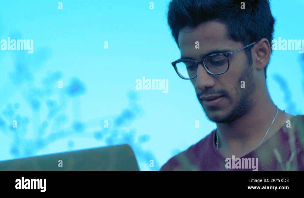 Close-up, Indian Guy in Spectacles Looks at Laptop Screen and Type Text ...