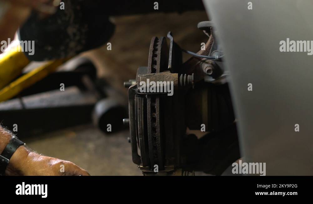 Automobile mechanic removing old worn out break plate for replacement ...