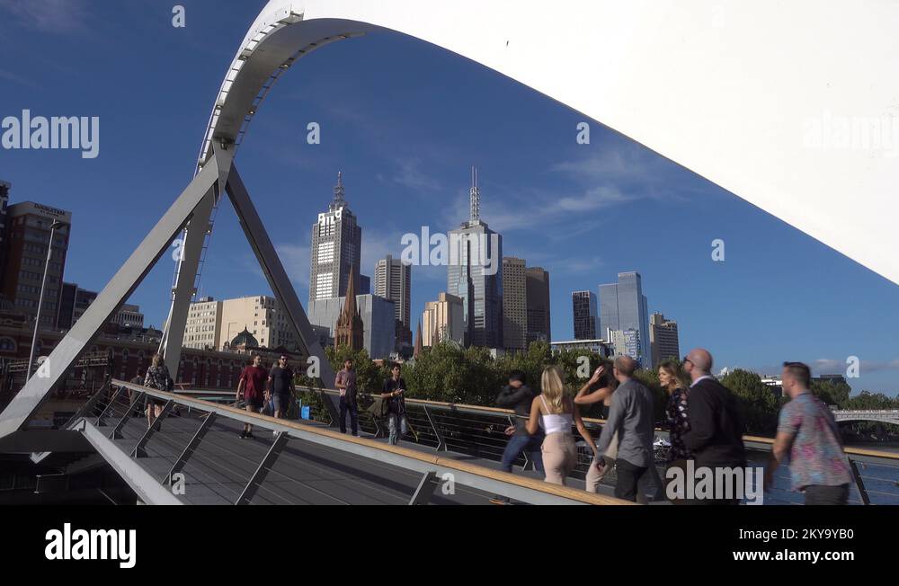 People walk over the pedestrian bridge, Melbourne skyline, Australia ...