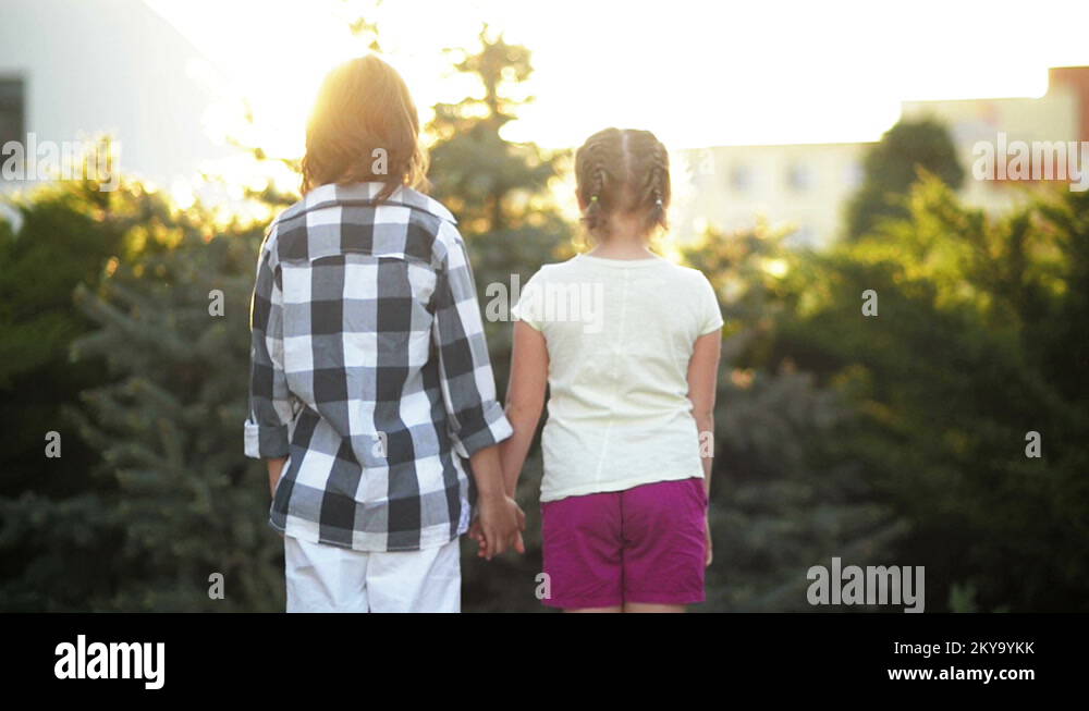 Two Children Stand Back And Hold Hands. Portrait of the Children's Back ...