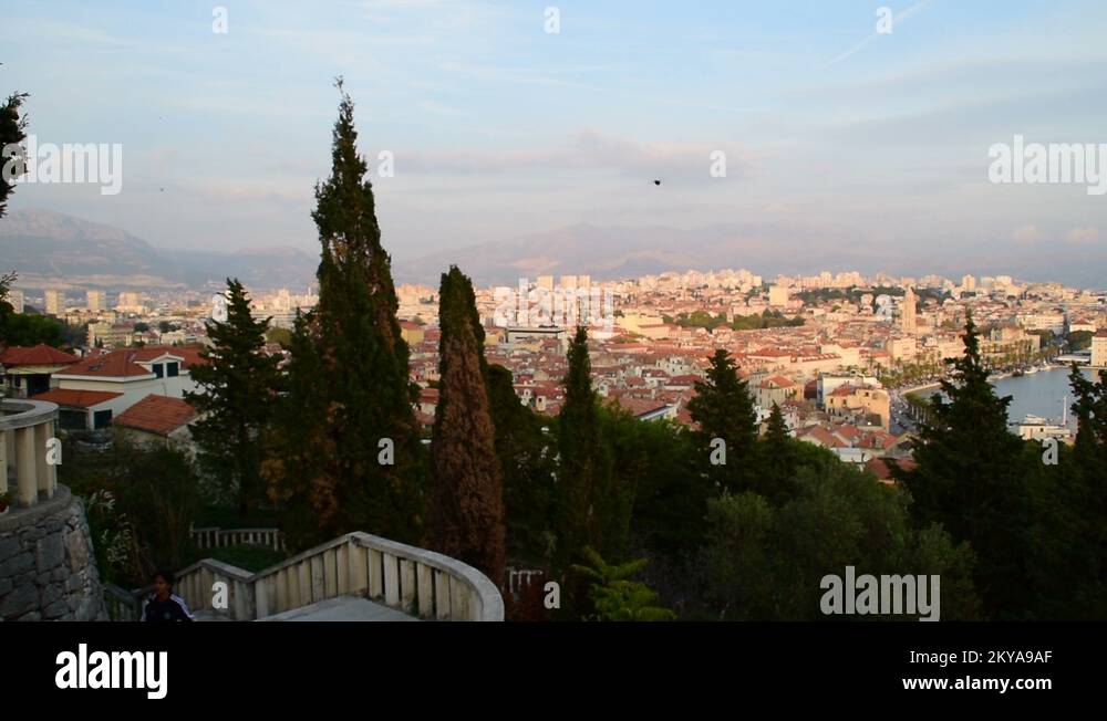 Pan of A tourist woman takes pictures of the Split panorama from the ...