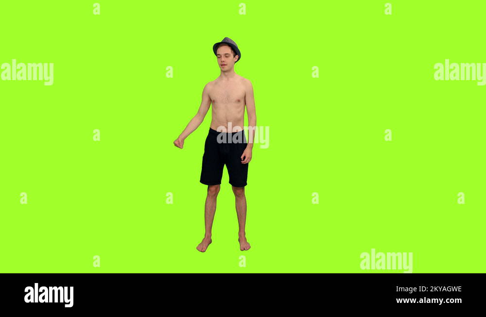 Young man posing and shows his muscles on green screen background ...