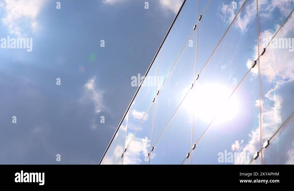 A windowed building reflects the bright sun - view from below Stock ...