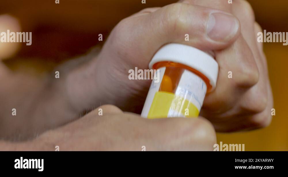 Man struggling and having difficulty opening a pill bottle - close up ...