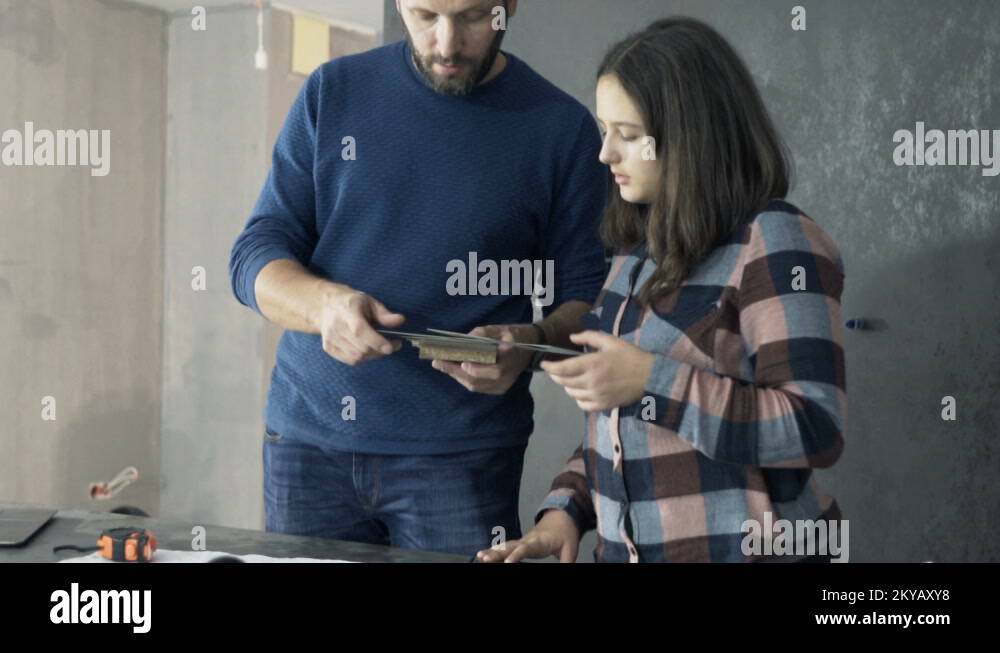 Father and daughter choosing colour from palette for their new home ...
