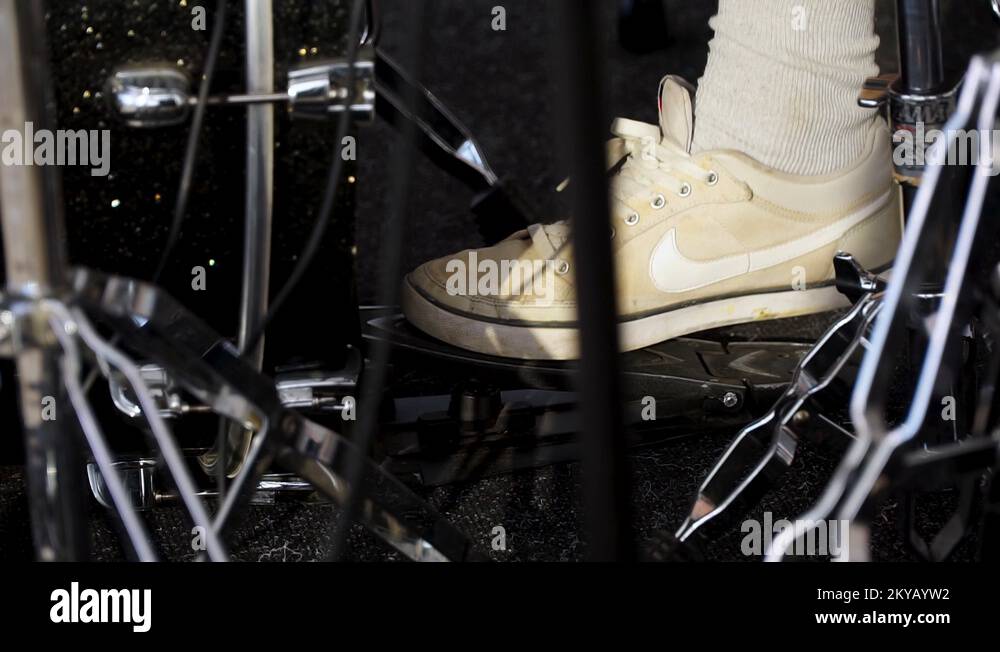 Drummer's foot in sneakers moving drum bass pedal. Clip. Part of legs ...