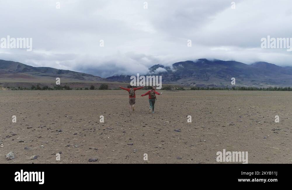 travelers run and joyfully wave their arms. guy and girl tourists are ...