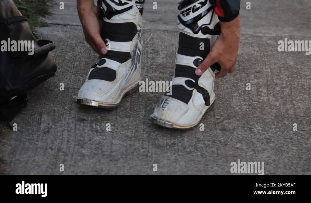 Motocross athlete taking off his boots Stock Video Footage - Alamy