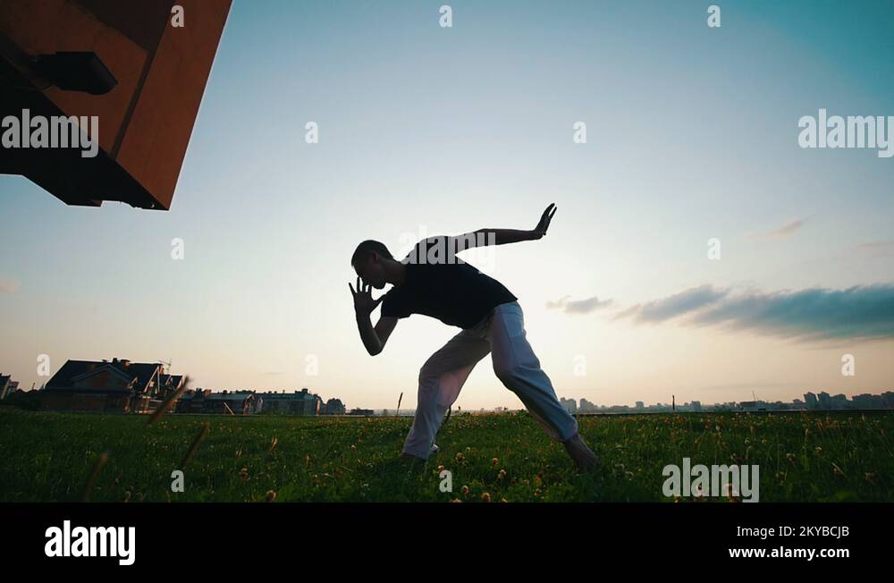 Man dancing capoeira, throwing back his legs, flies up in the air ...