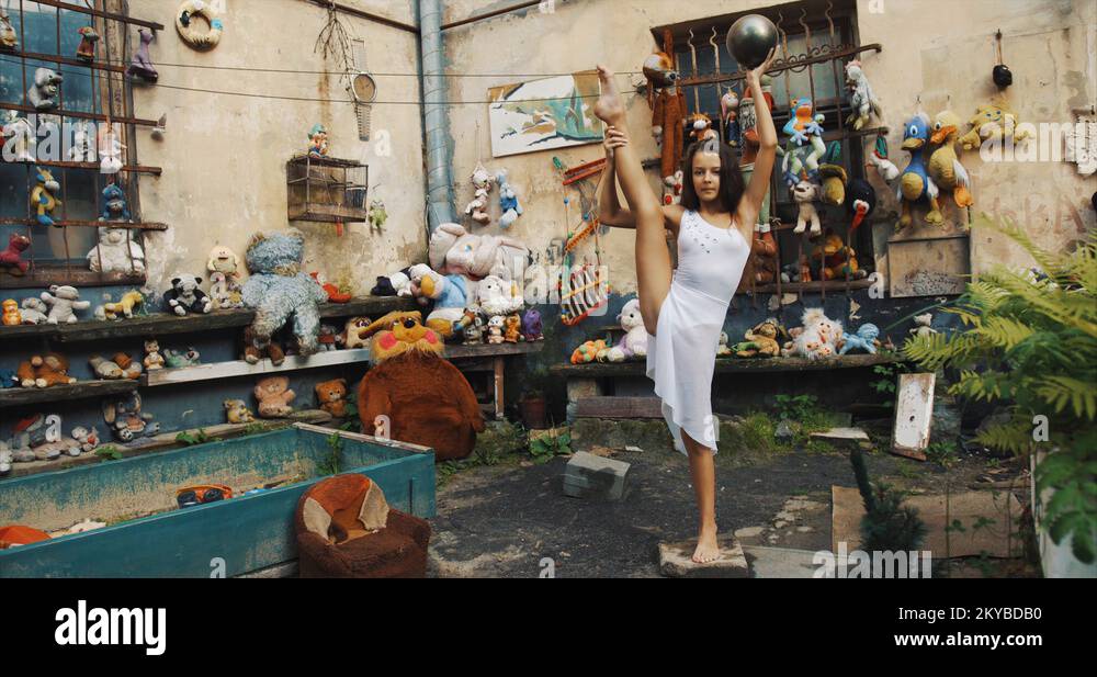 Pretty little girl is spinning silver ball on her finger. Cute gymnast ...