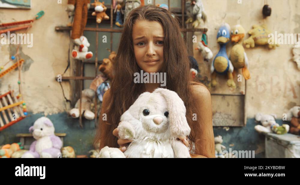 Close-up portrait of the little 10 years old girl holding the teddy ...